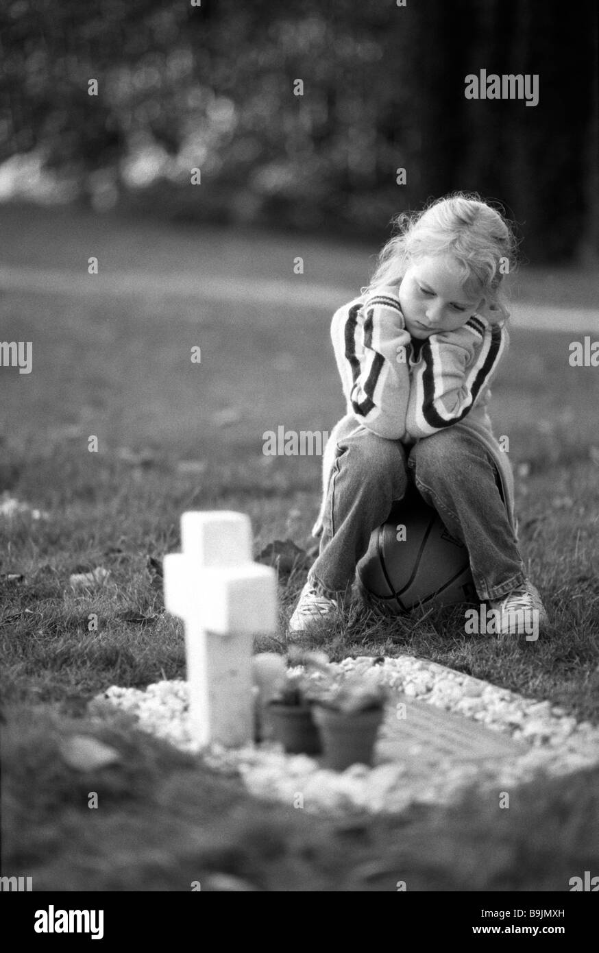 Girl mourning at cemetery Stock Photo - Alamy