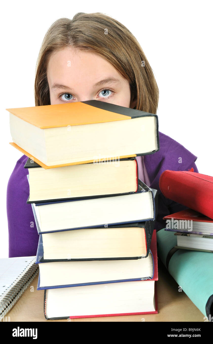 Frustrated teenage girl studying at the desk with big stack of books ...