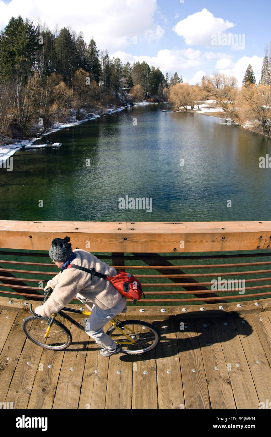 A man rides his bike over a wooden bridge crossing a river Stock Photo ...