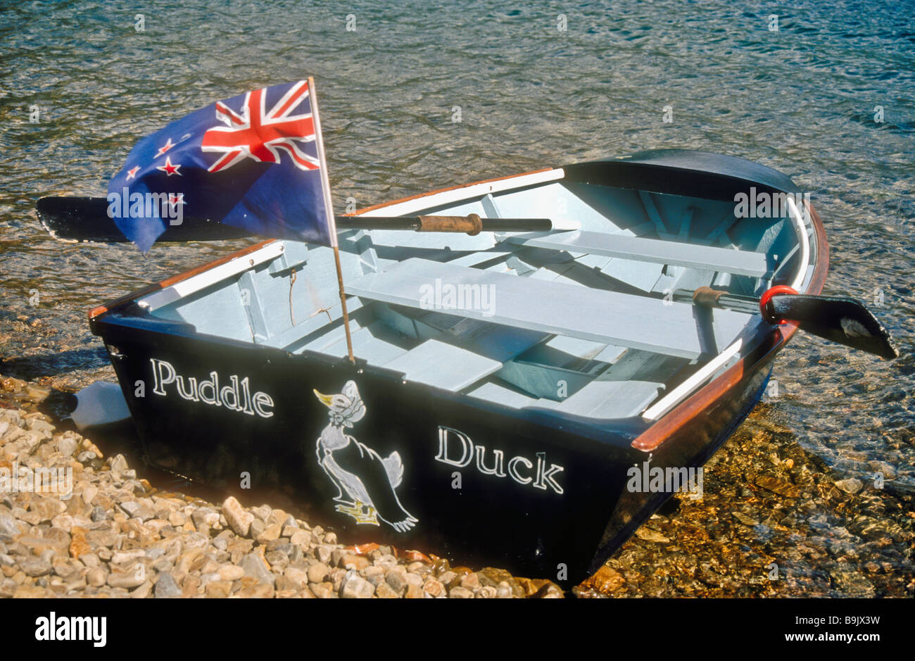 A wooden rowing dinghy flying the New Zealand Blue Ensign at Lake ...
