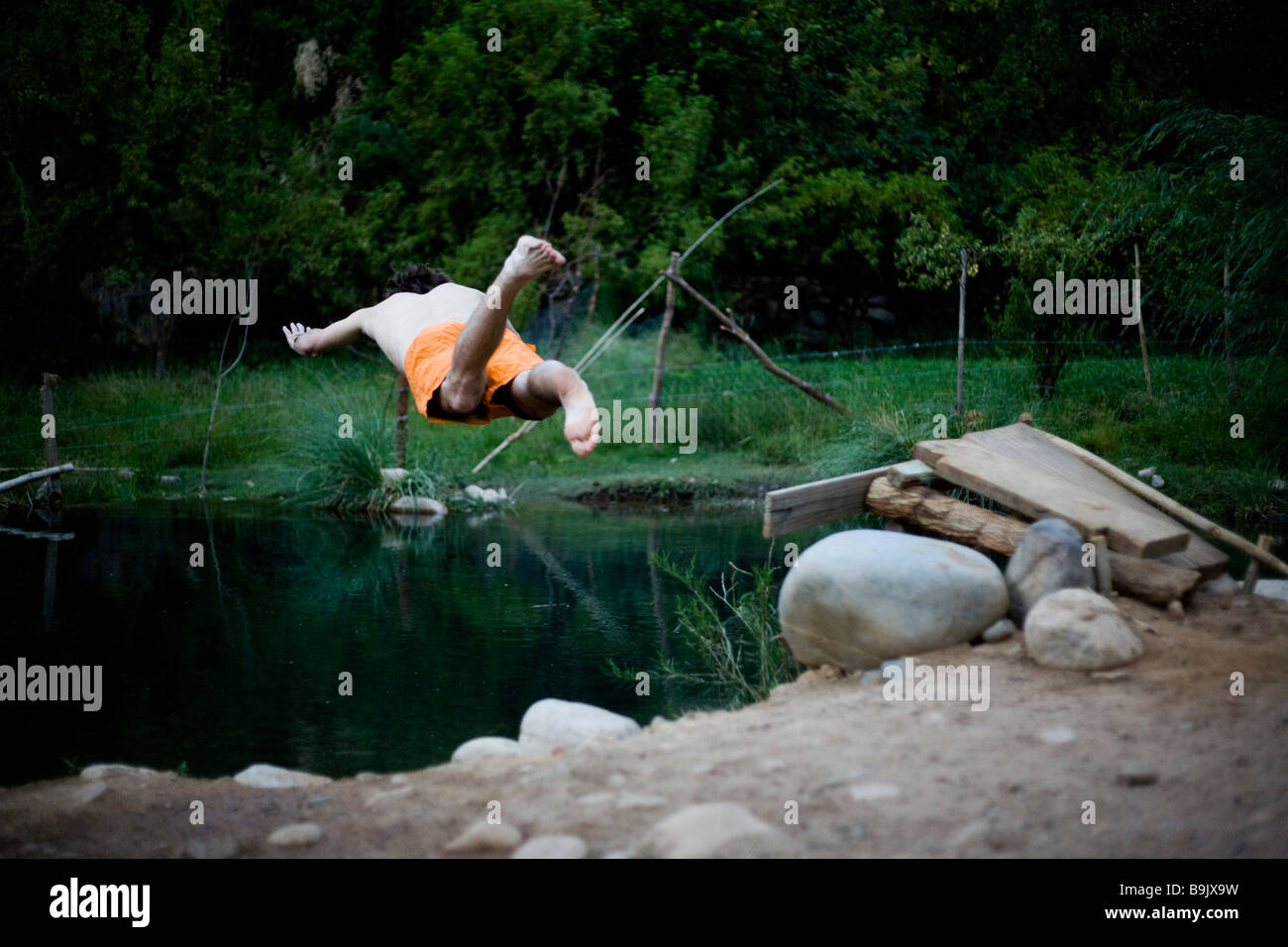 A young man dives into a small swimming hole Stock Photo - Alamy