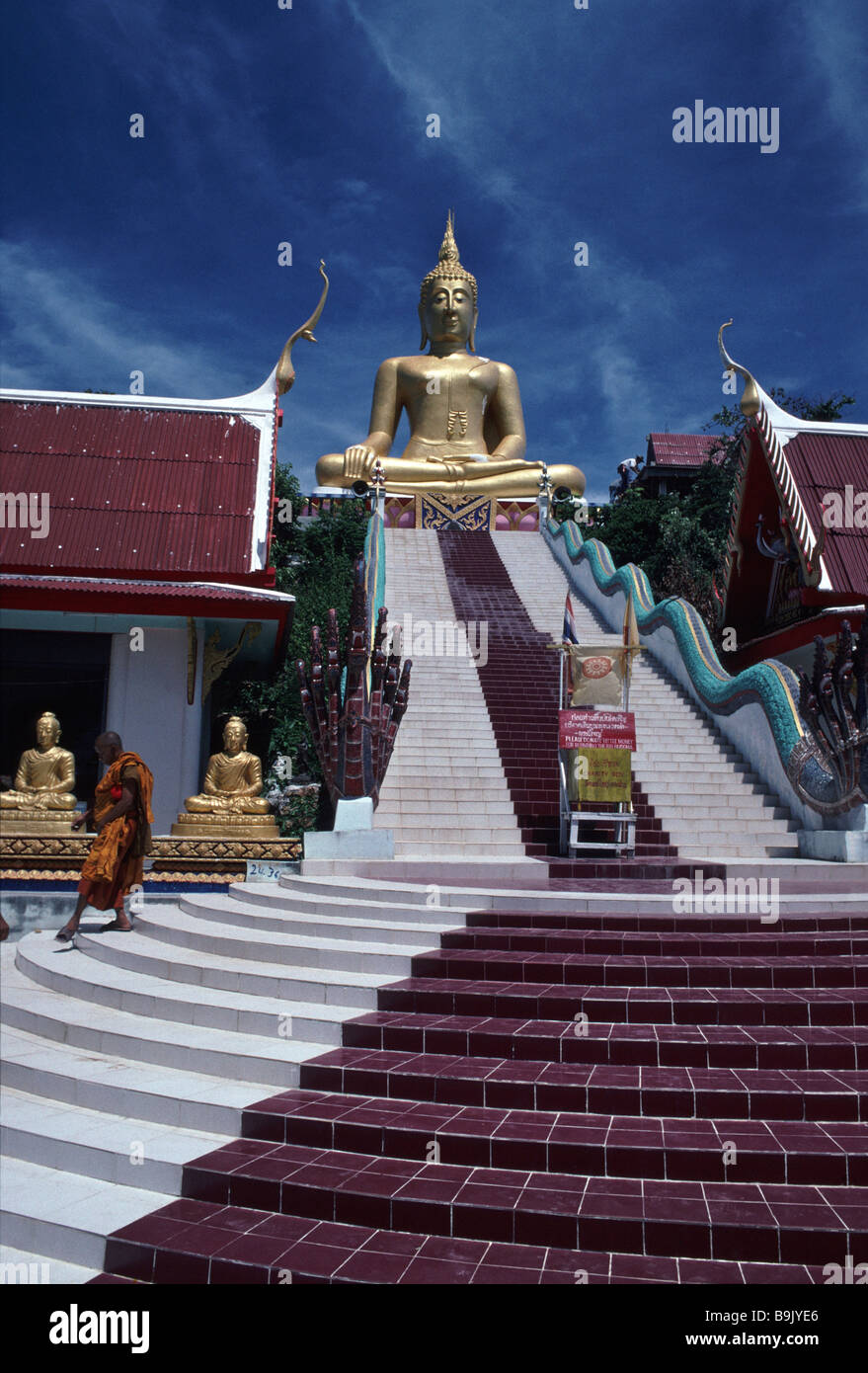 An elderly Buddhist monk descends the stairs leading to the big Buddha ...