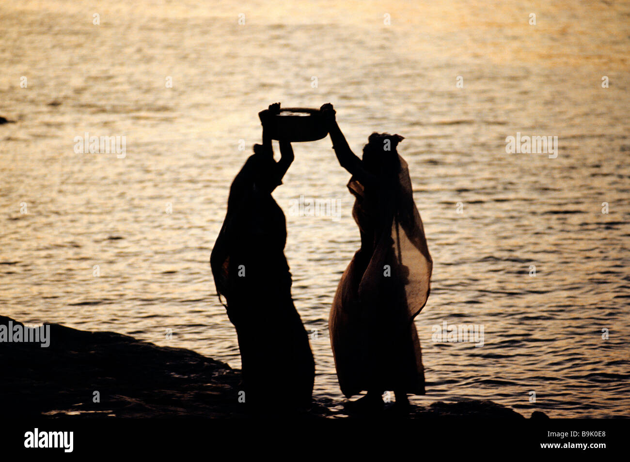 India, Madhya Pradesh, Omkareshwar, two women helping each other ...
