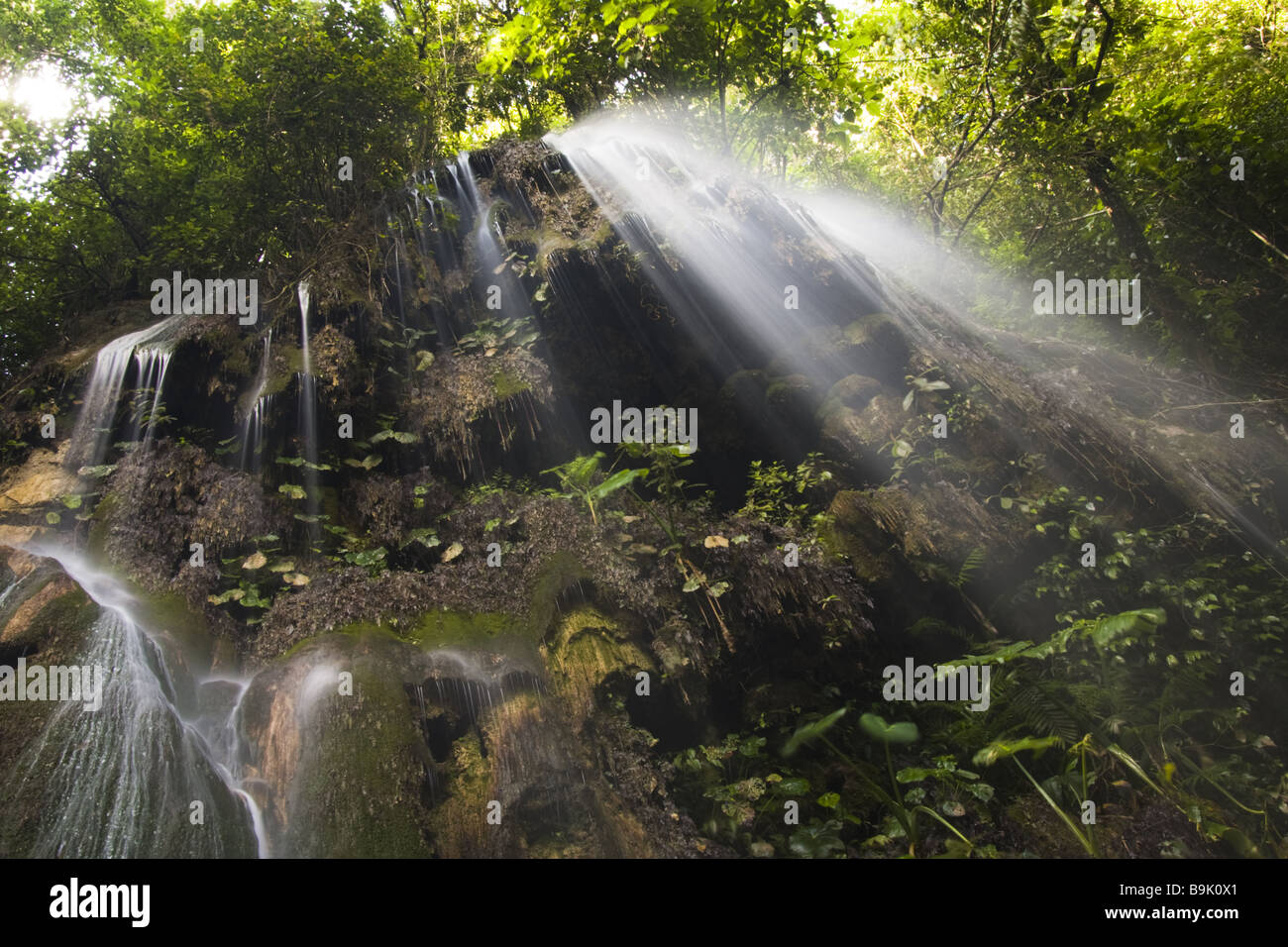 A waterfall cascades through lush jungle vegetation near the Lacandon ...