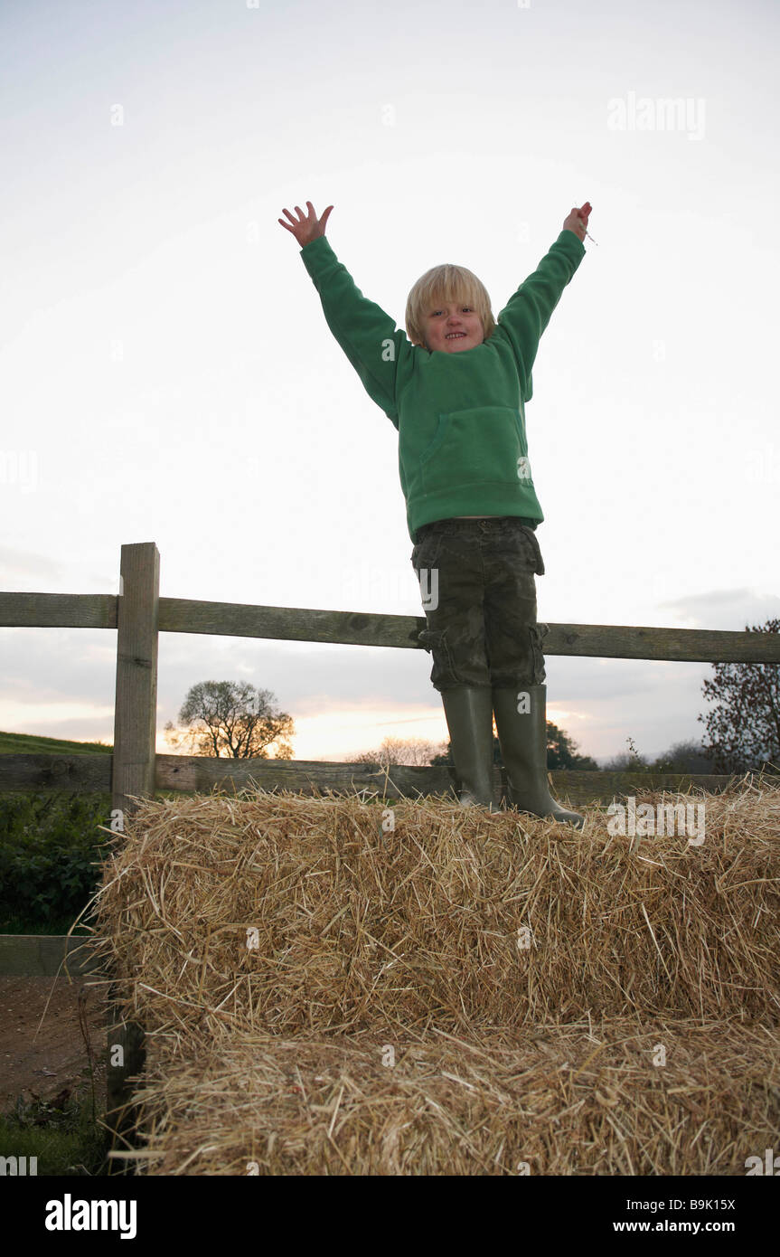 Young boy on hay bales Stock Photo - Alamy