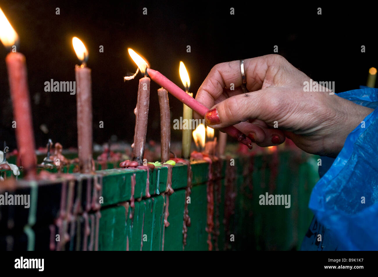 A woman lights a candle at a shrine at the Abul Fazel Mosque, in an old ...