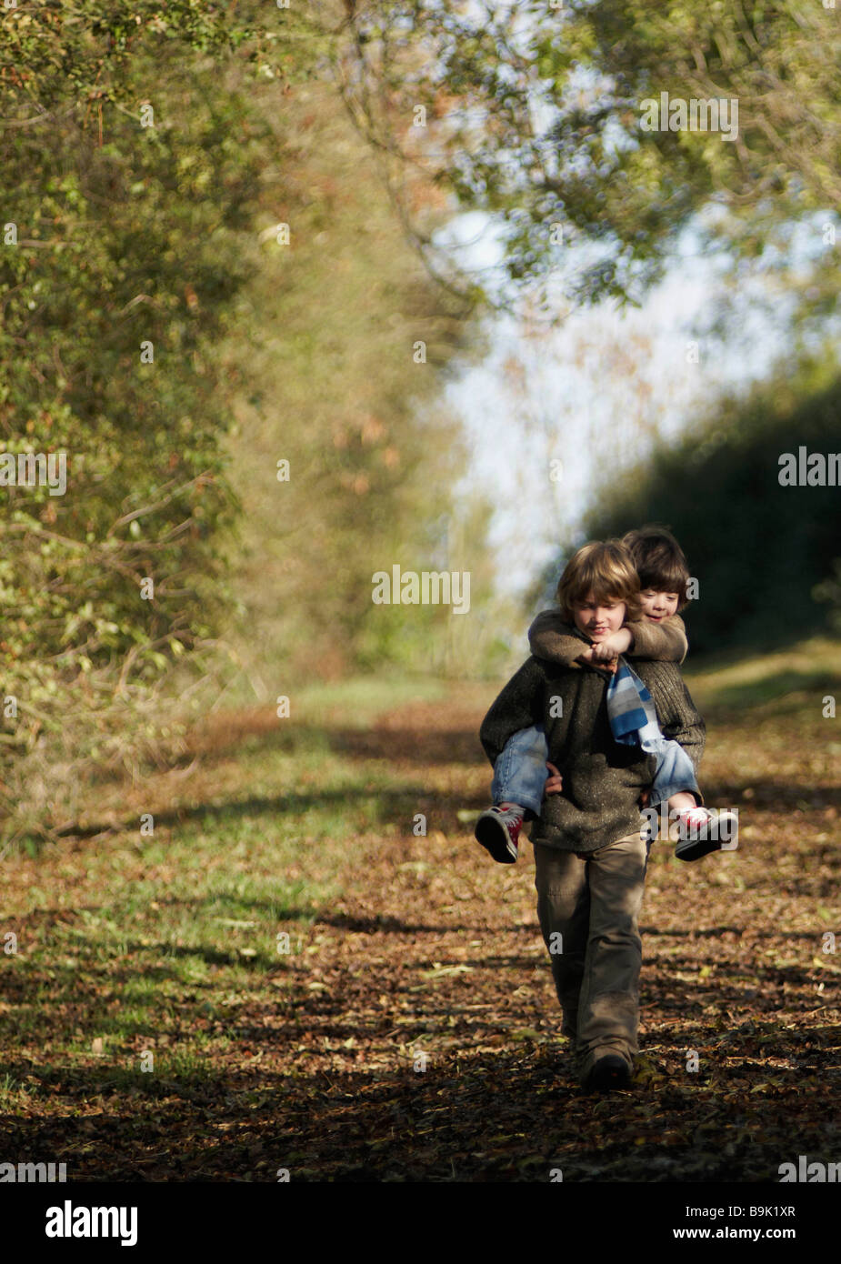 Boy carrying young child in countryside Stock Photo - Alamy