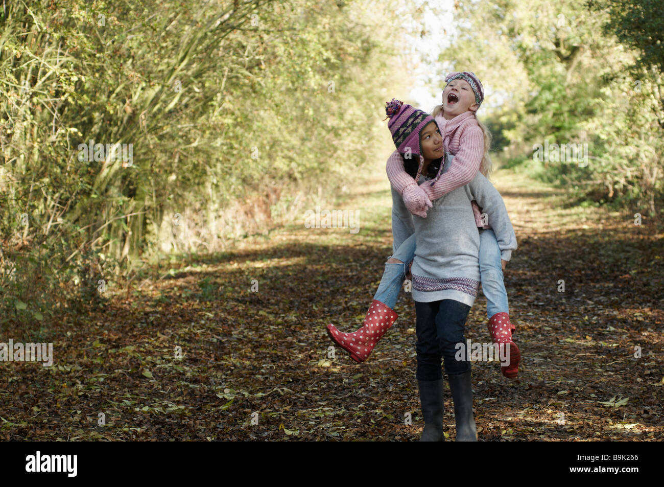 Girl carrying friend in countryside Stock Photo - Alamy
