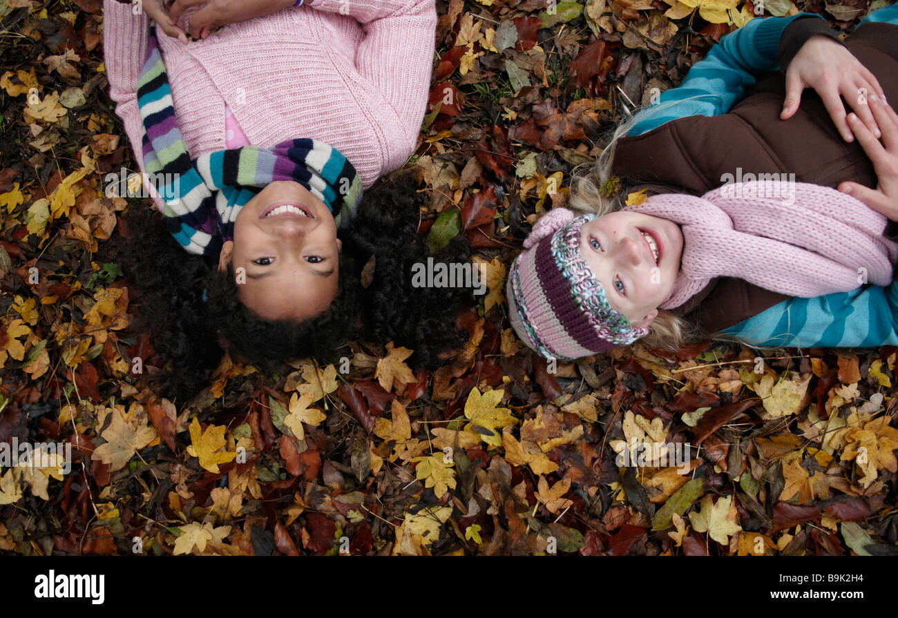 Two friends lying on autumn leaves Stock Photo - Alamy