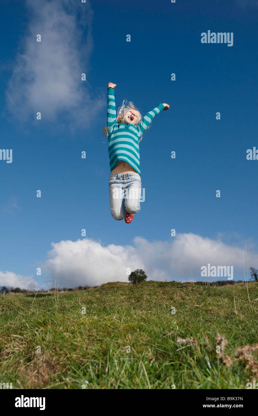 Girl jumping on hill Stock Photo - Alamy