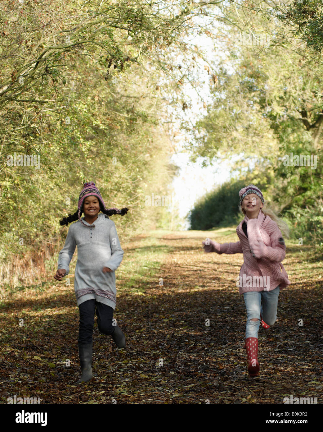 Girls running down country lane Stock Photo - Alamy