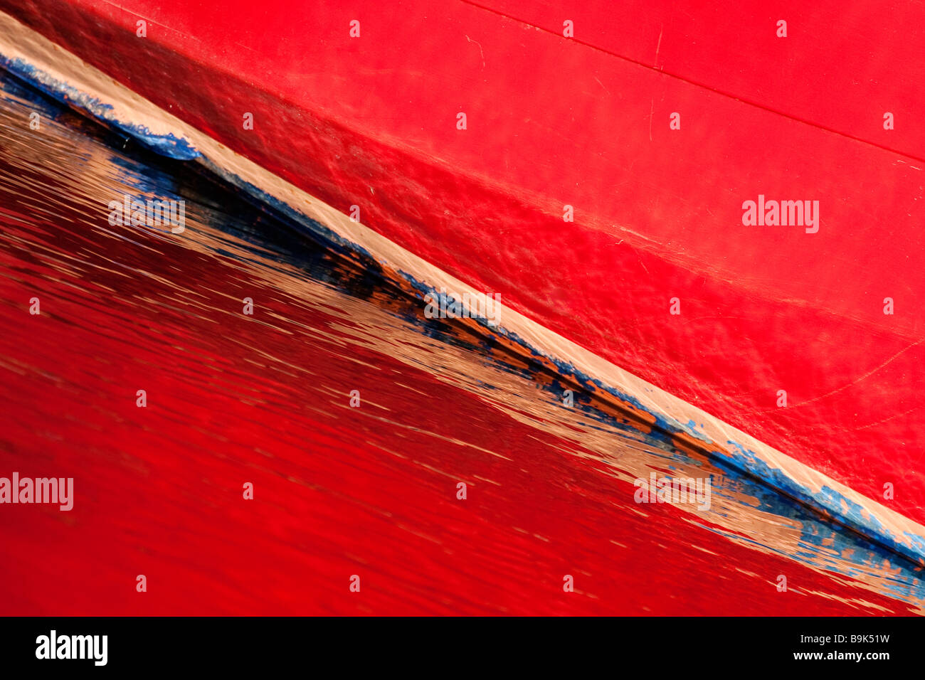 Red painted boat hull detail reflecting in the river Stock Photo - Alamy