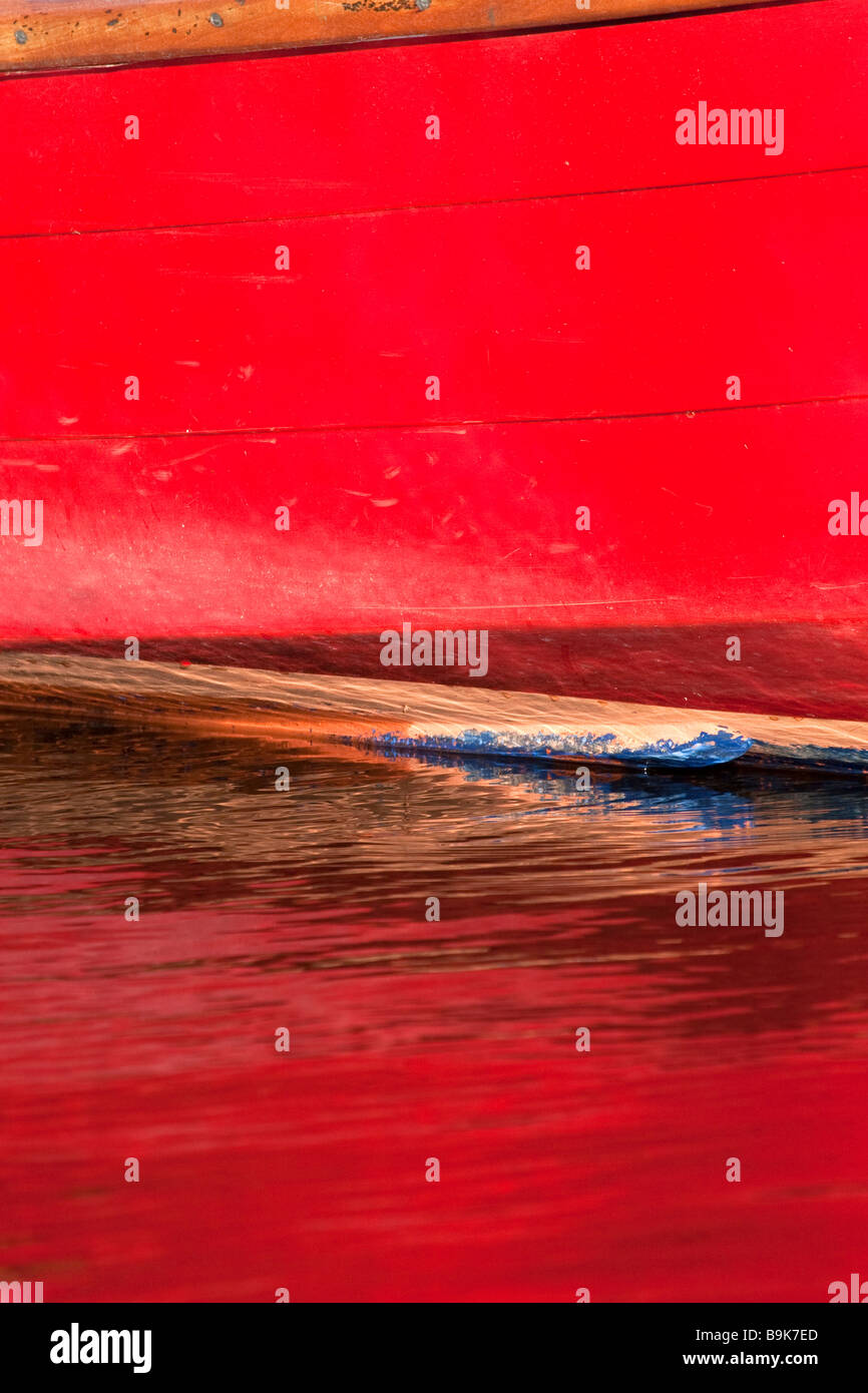 Red painted boat hull detail reflecting in the river Stock Photo - Alamy