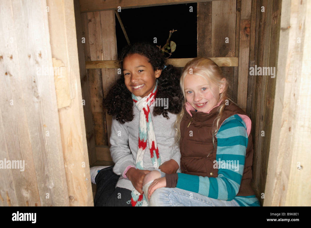 Two young girls in treehouse Stock Photo - Alamy