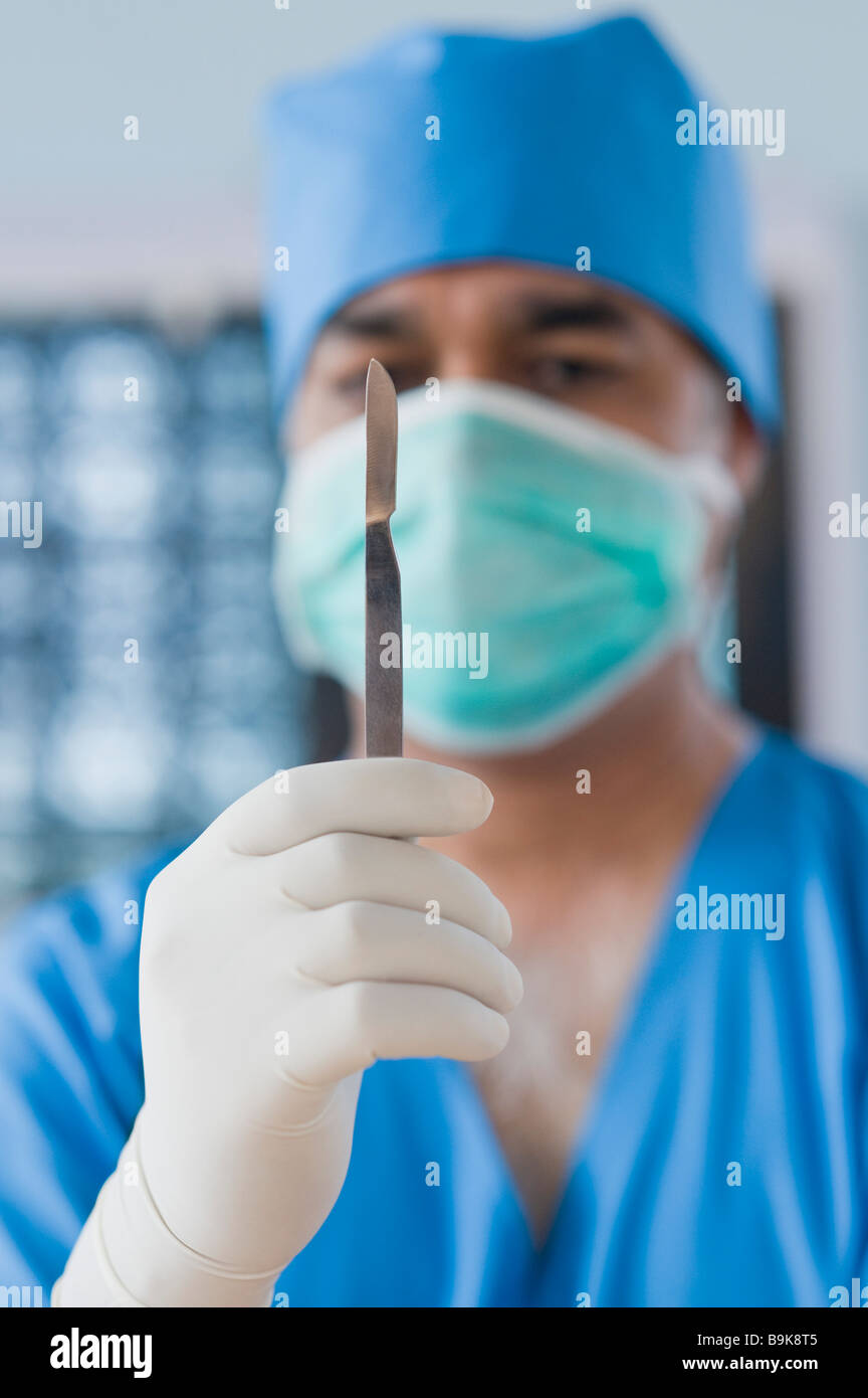Surgeon holding a scalpel Stock Photo - Alamy
