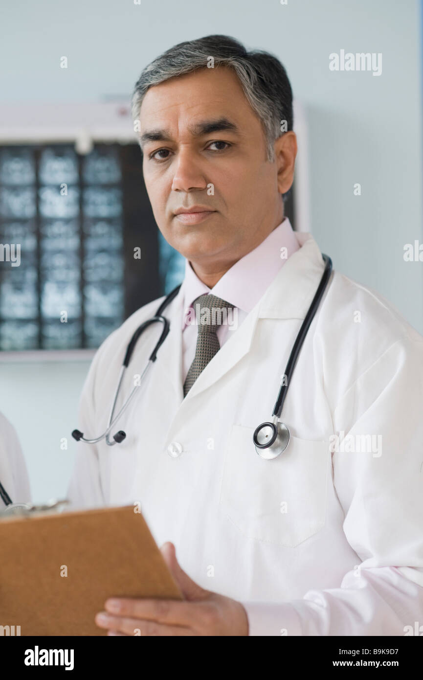 Portrait of a doctor holding a clipboard Stock Photo - Alamy