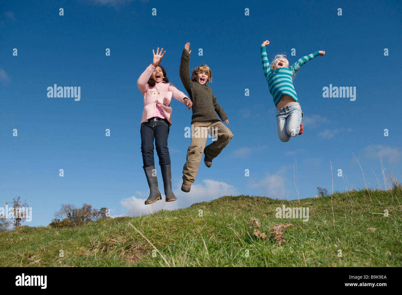 Children jumping on hill Stock Photo - Alamy