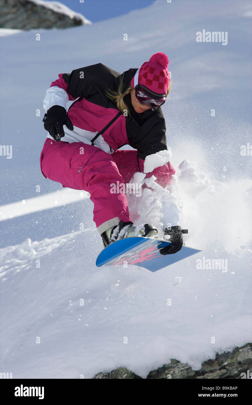 Female snowboarder jumping with a grab Stock Photo - Alamy