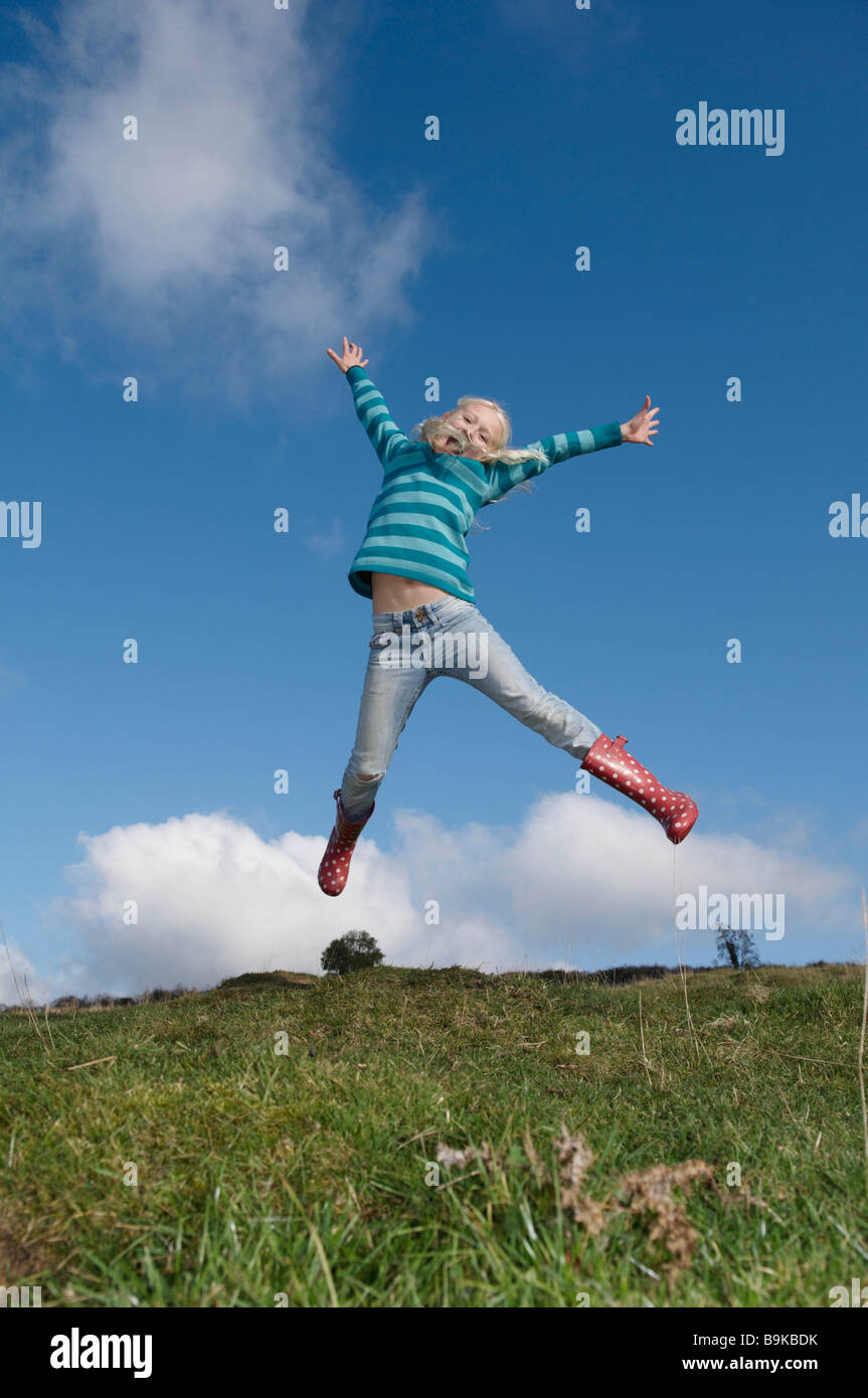 Girl jumping on hill Stock Photo - Alamy