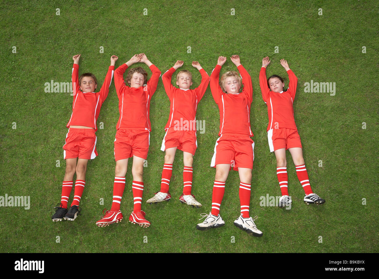 Footballers lying in a line Stock Photo - Alamy