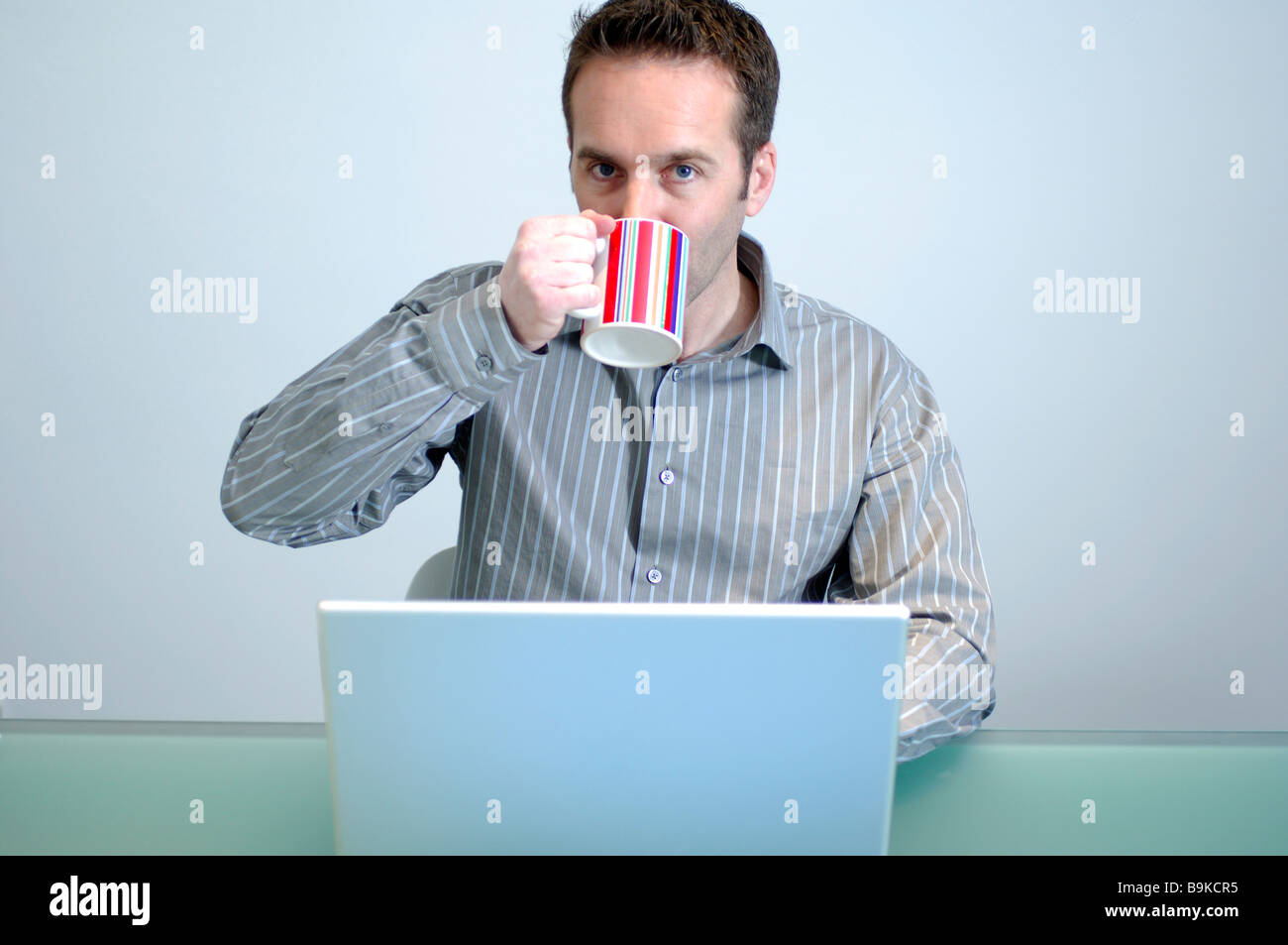 businessman sitting behind computer drinking some coffee Stock Photo ...