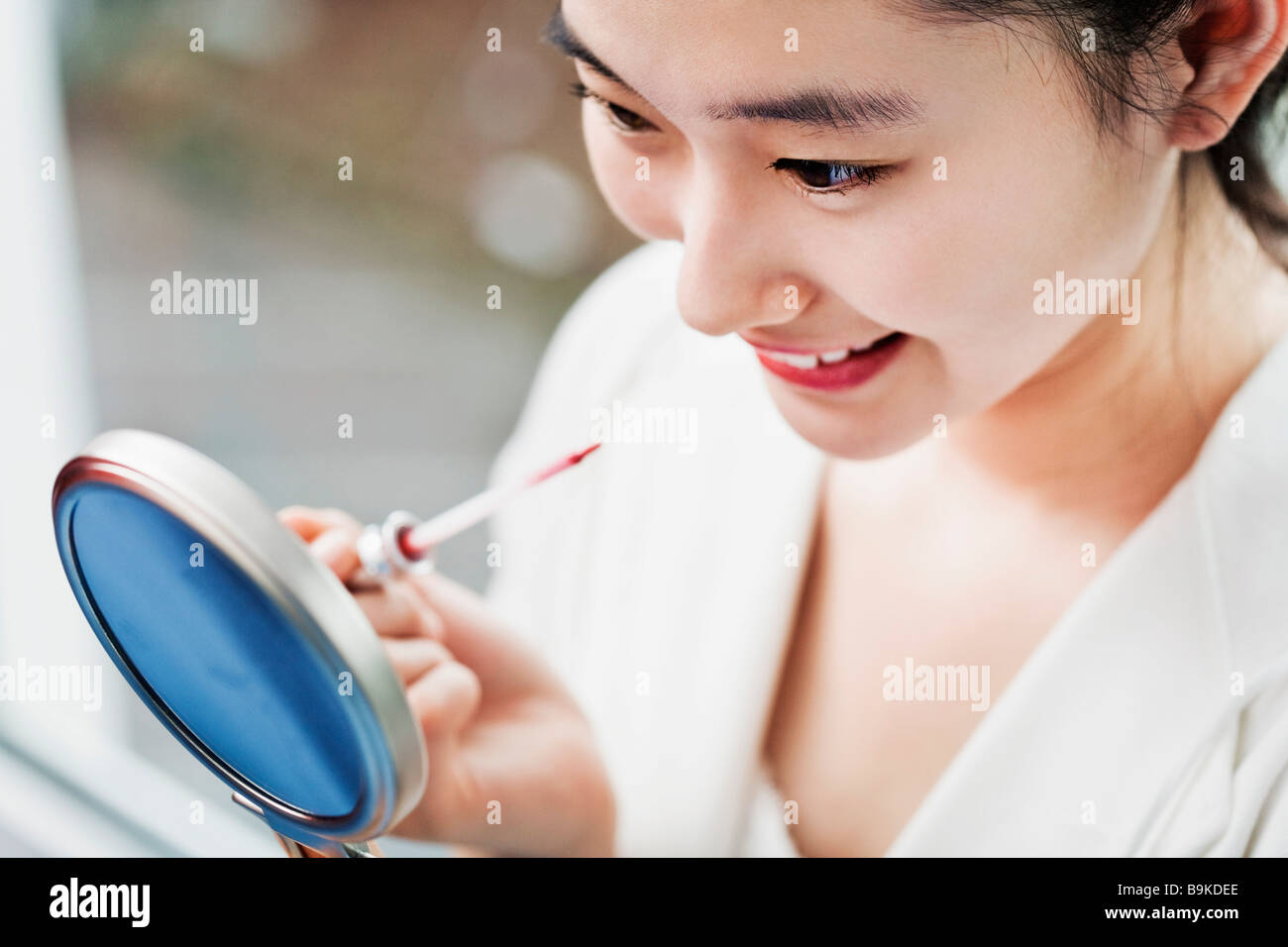 portrait of japanese girl applying lip-gloss Stock Photo - Alamy