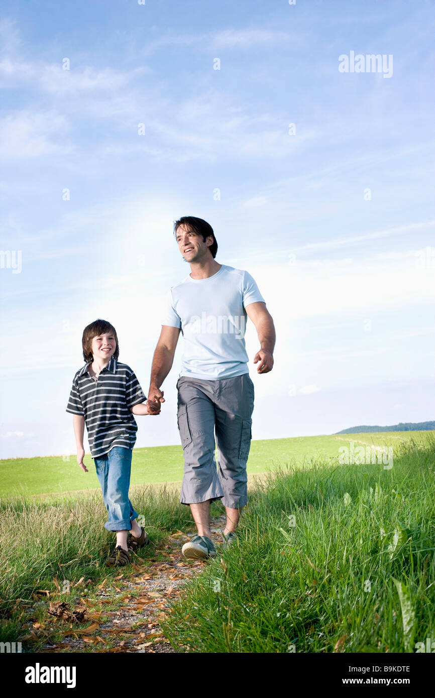 young father and his son walking on path in the countryside Stock Photo ...