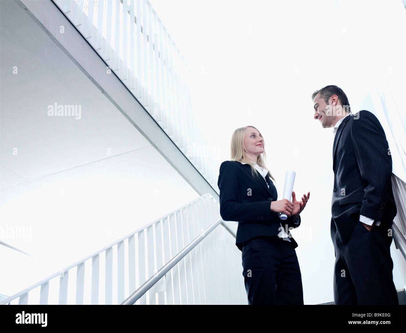 young businesswoman and man having conversation in office building ...