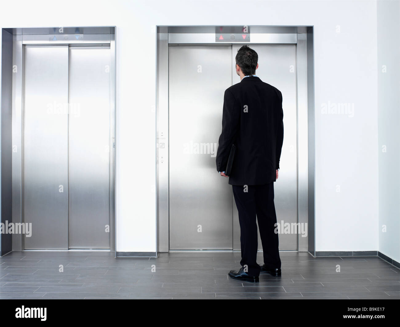 young businessman standing in front of elevator Stock Photo - Alamy