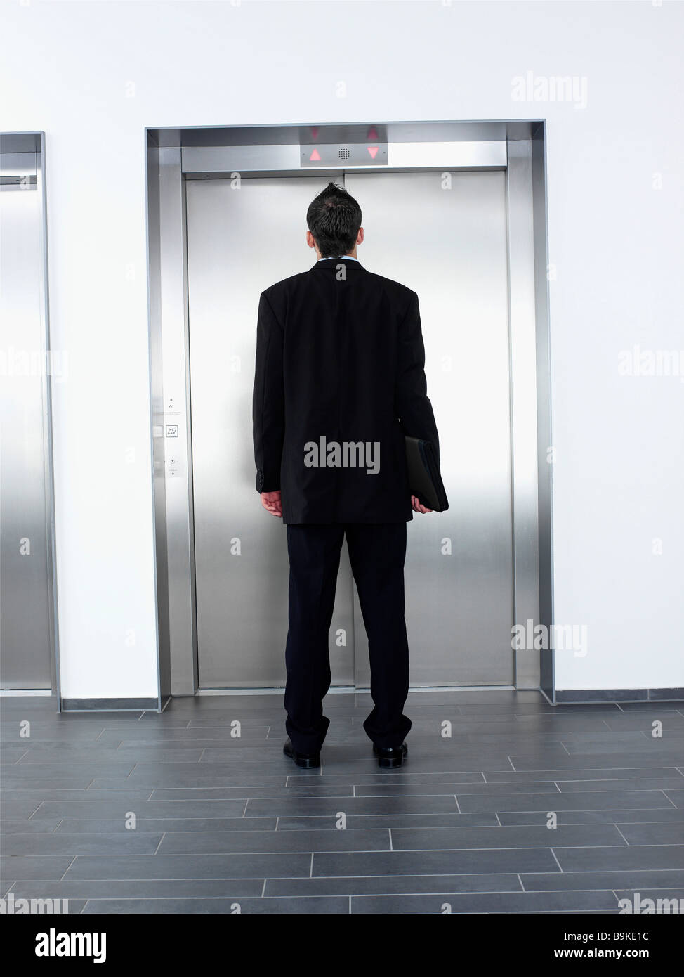 young businessman standing in front of elevator Stock Photo - Alamy
