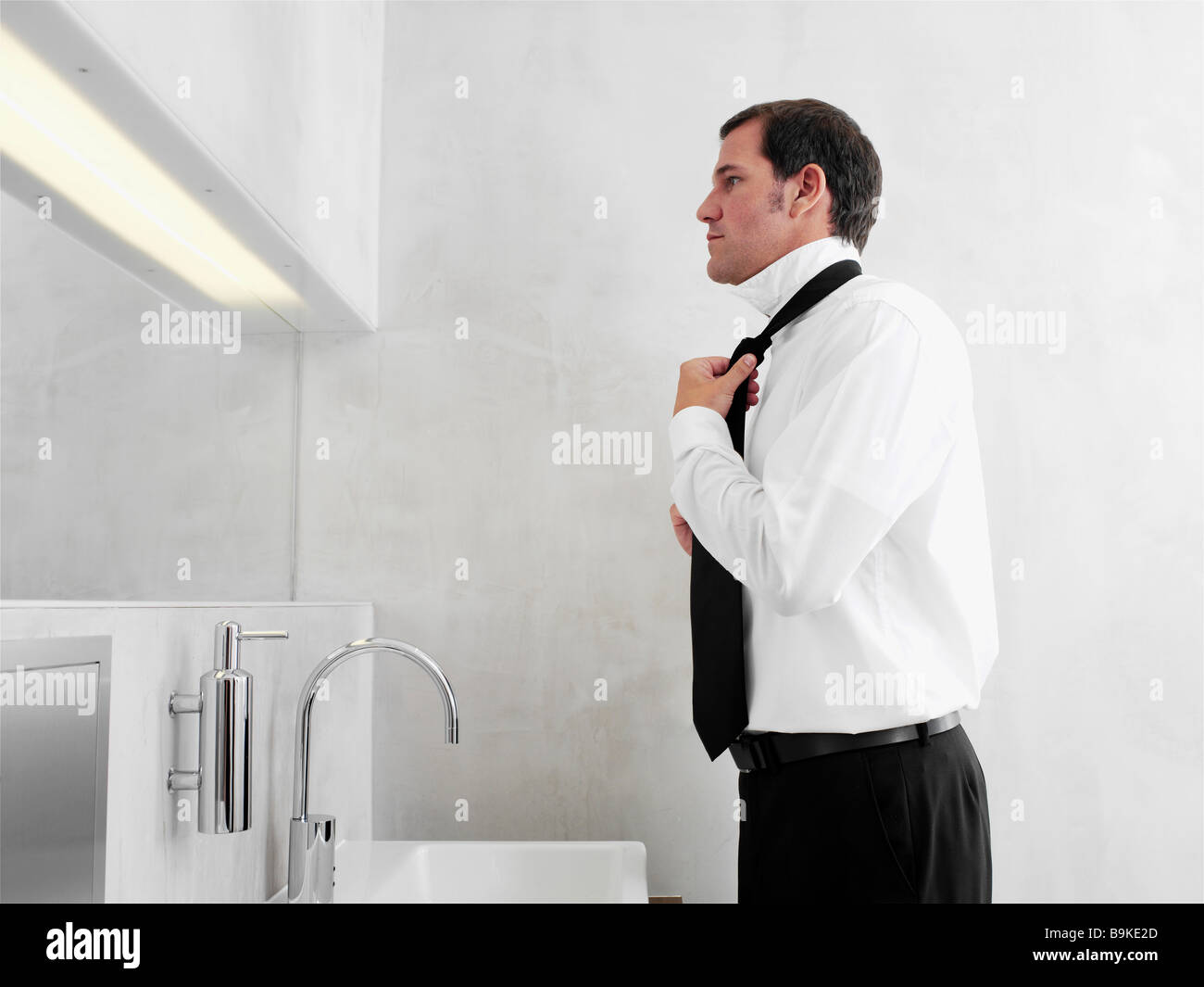 side view of businessman putting on his tie Stock Photo - Alamy