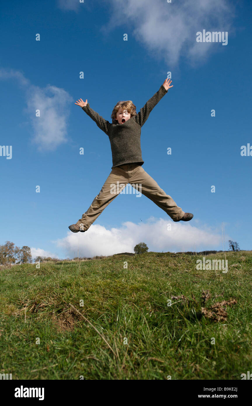 Boy jumping on hill Stock Photo - Alamy