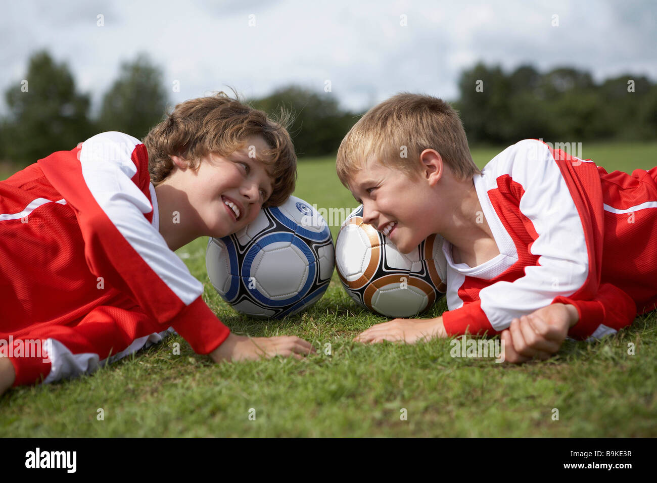 Two boys laughing with heads on balls Stock Photo - Alamy