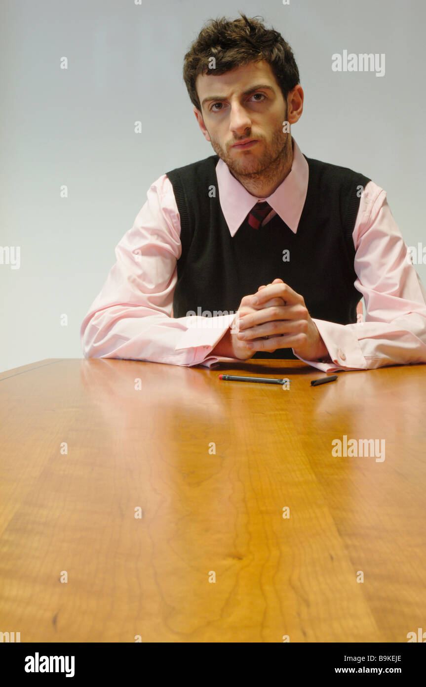 portrait of annoyed businessman sitting at conference table Stock Photo ...