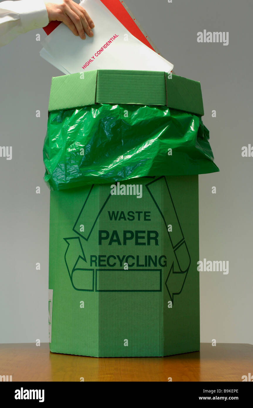 female hand putting confidential file in wastebasket for paper ...