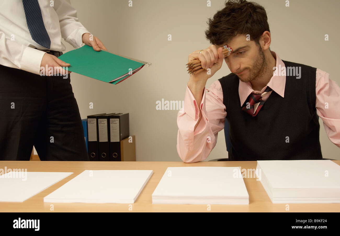 frustrated businessman sitting at desk full of documents colleague ...