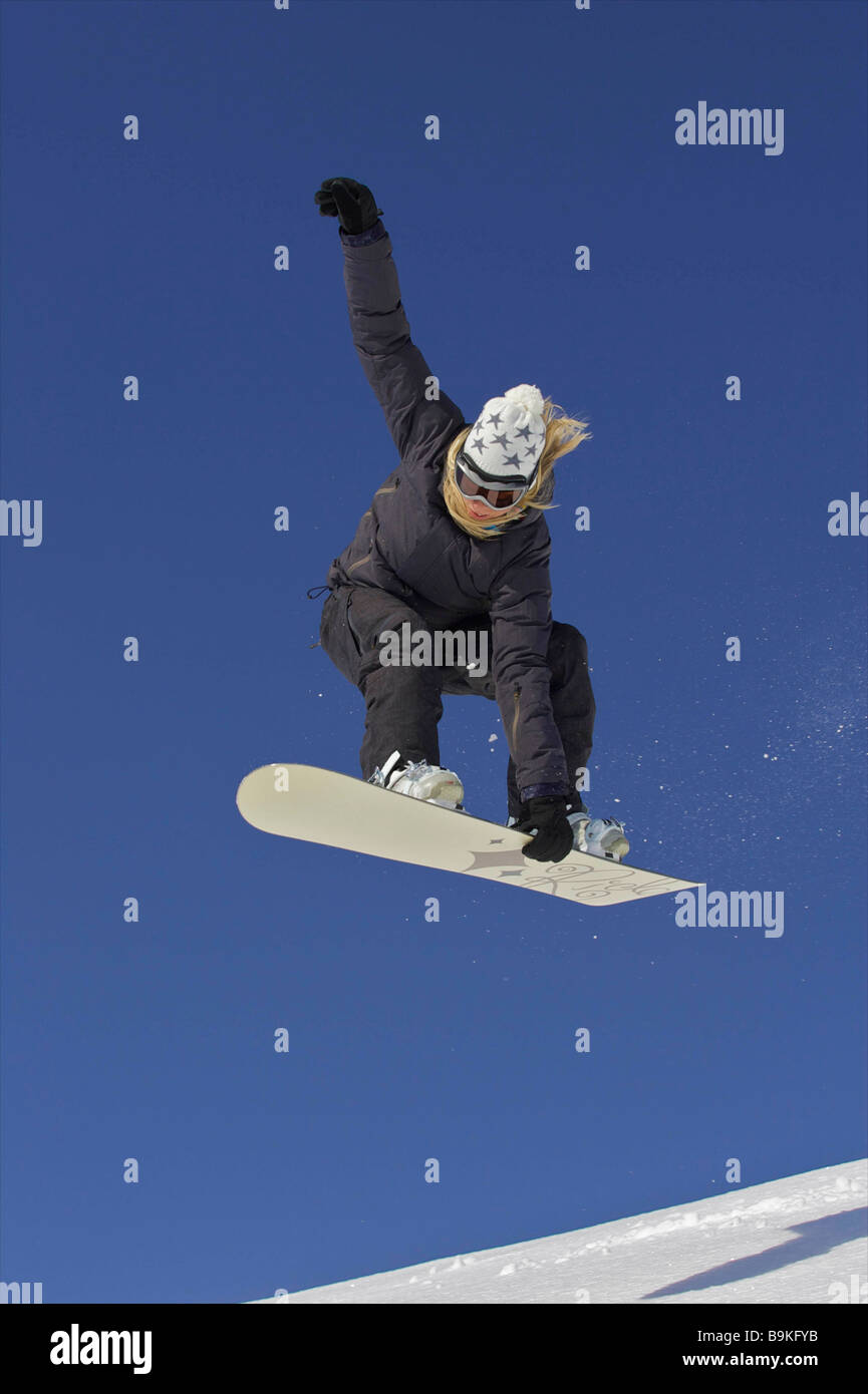 Female snowboarder jumping with a grab Stock Photo - Alamy