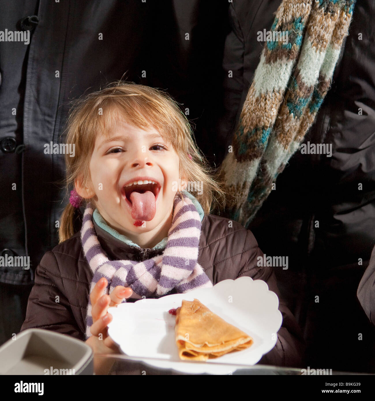 Girl eating crepe with jam Stock Photo - Alamy
