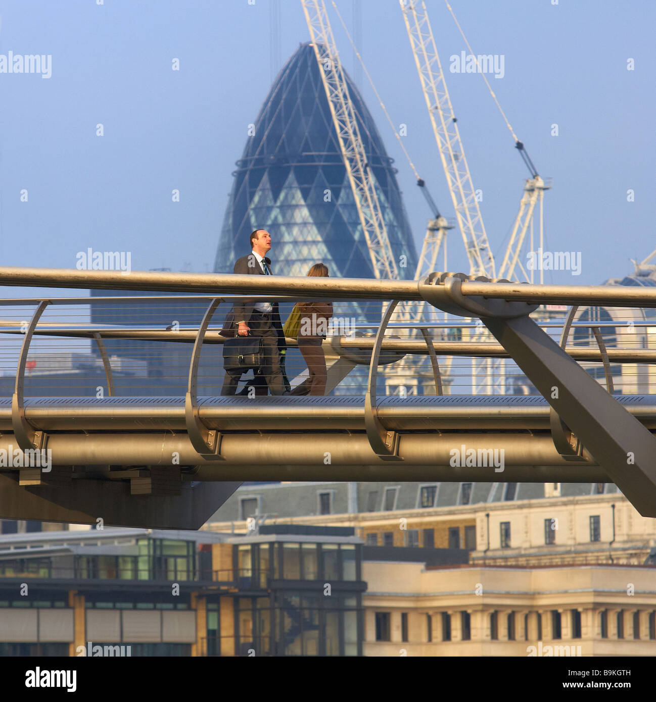 A city business man walks across the London Millennium bridge in the ...