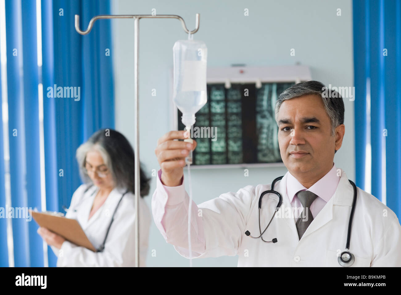 Doctor checking a saline drip Stock Photo - Alamy