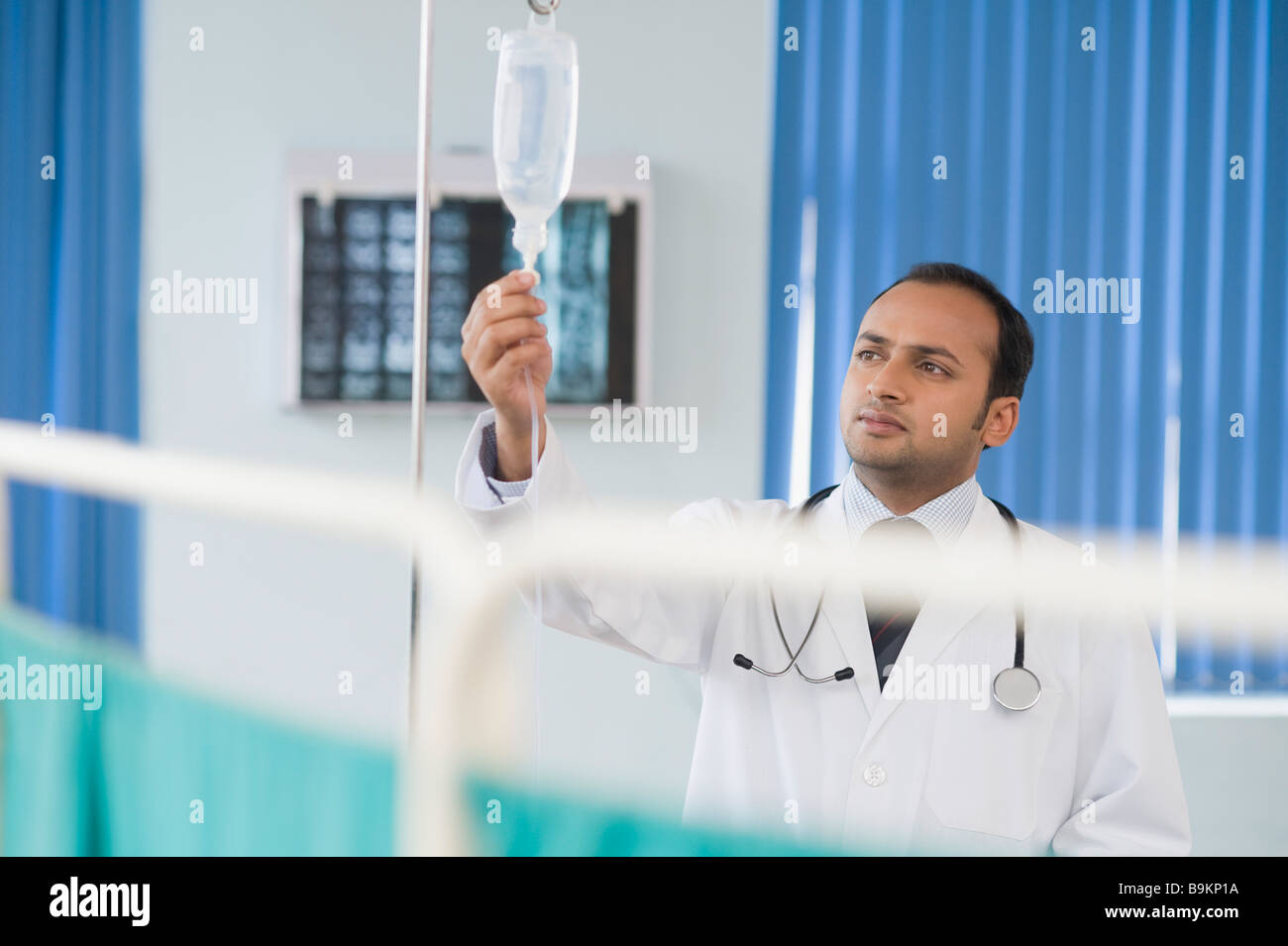 Doctor checking a saline drip Stock Photo - Alamy