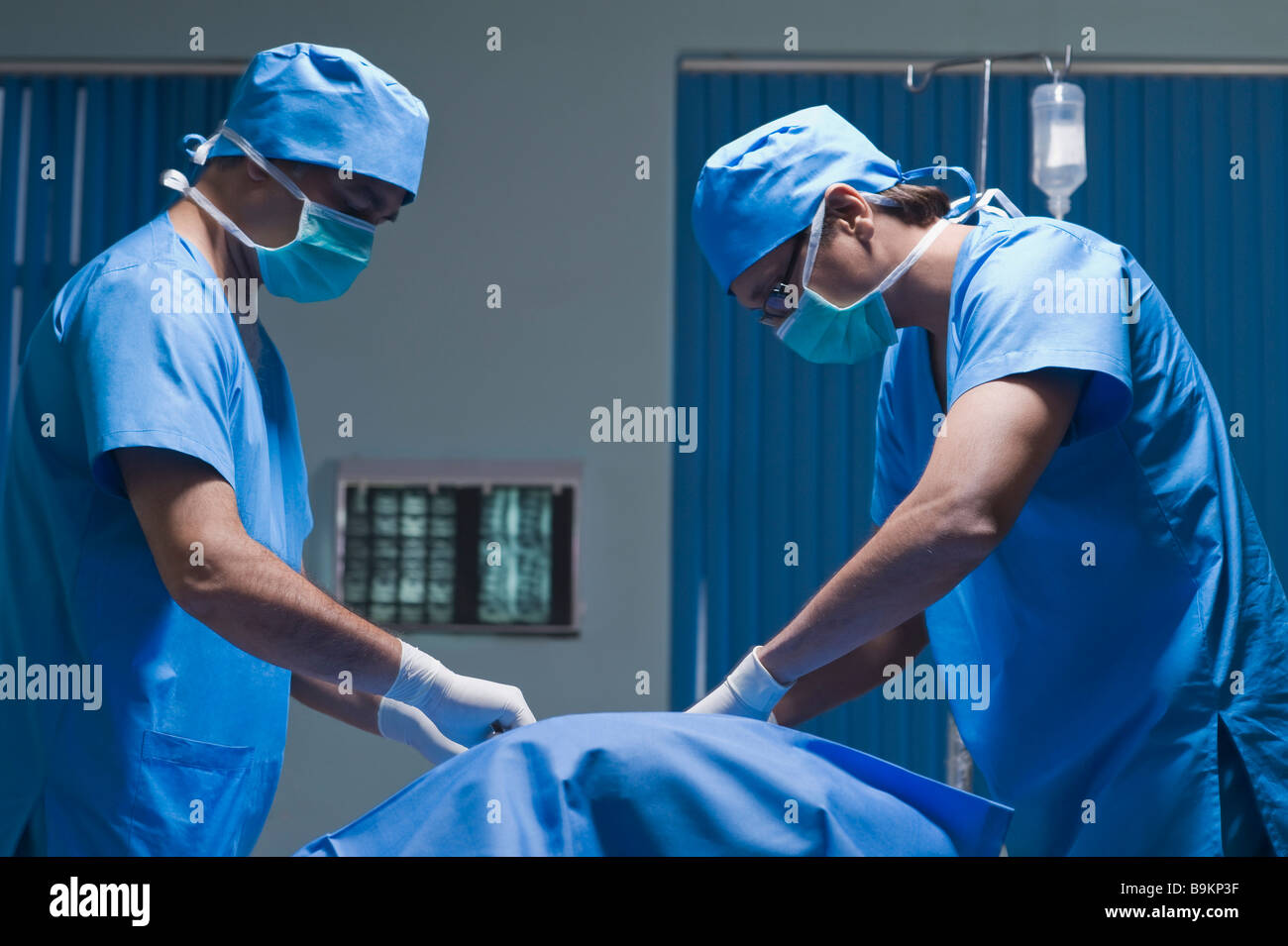 Two surgeons performing a surgery in an operating room Stock Photo - Alamy
