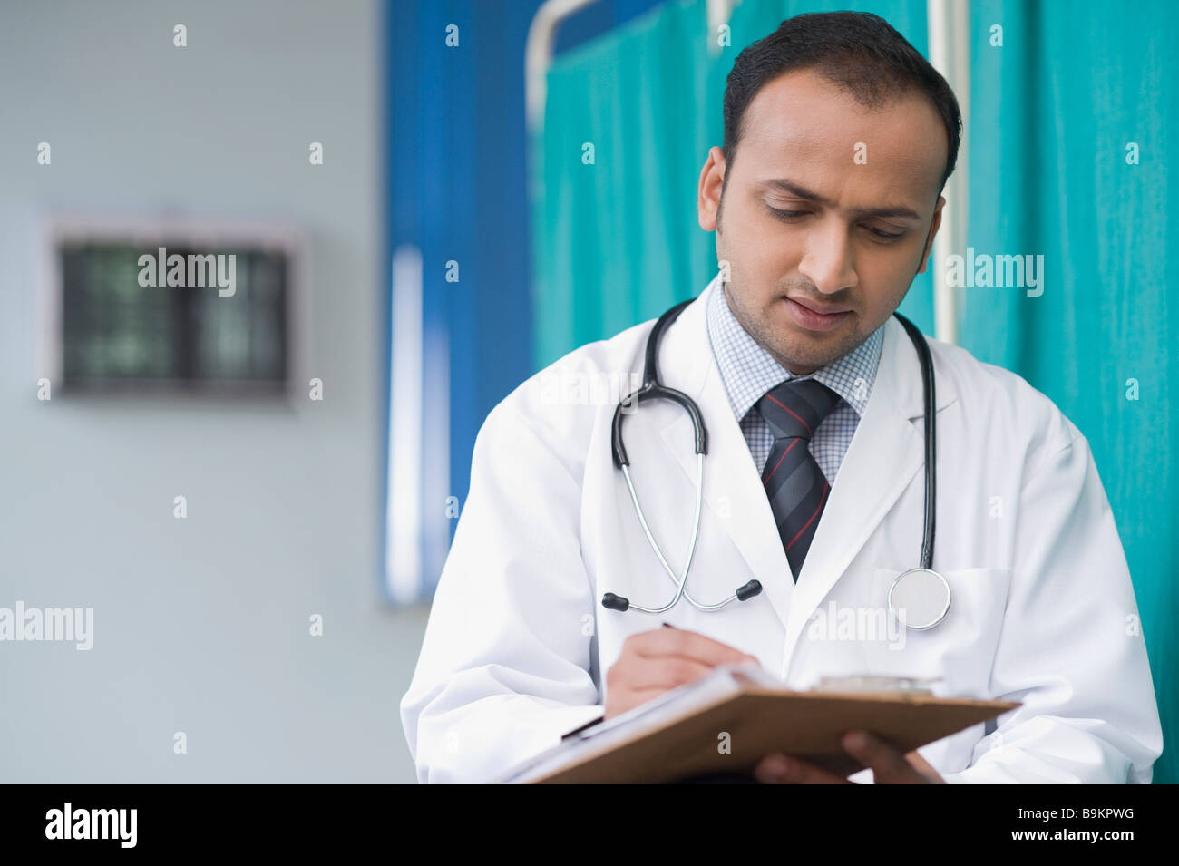 Doctor writing on a notepad Stock Photo - Alamy
