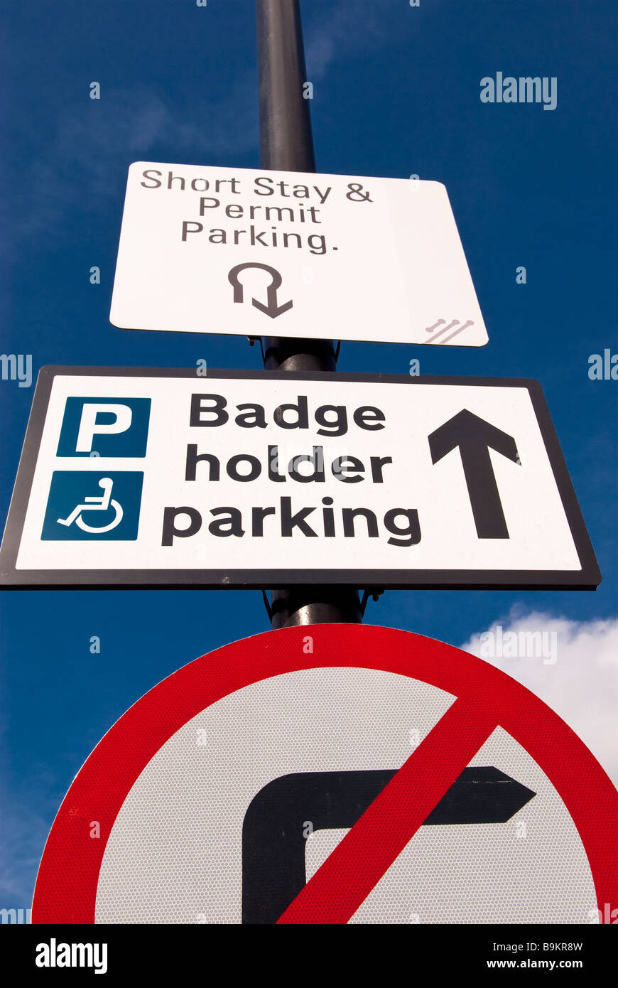A traffic sign saying badge holder parking and short stay & permit ...