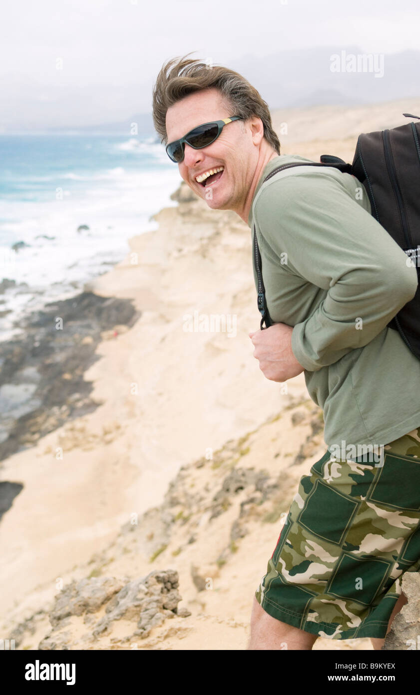 A happy smiling forties man carrying a rucksack is having fun on his ...