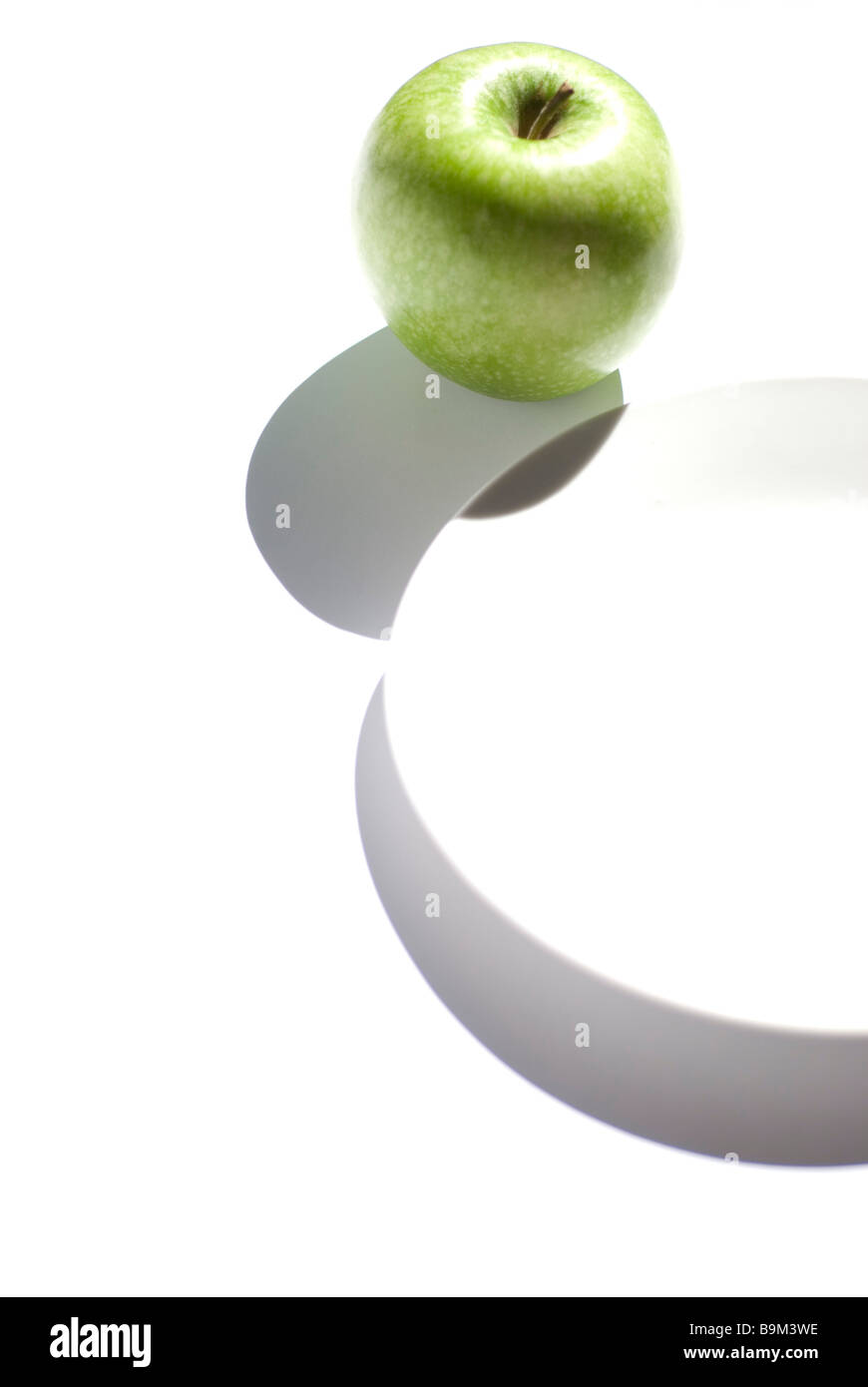 green apple outside of a plate Stock Photo - Alamy