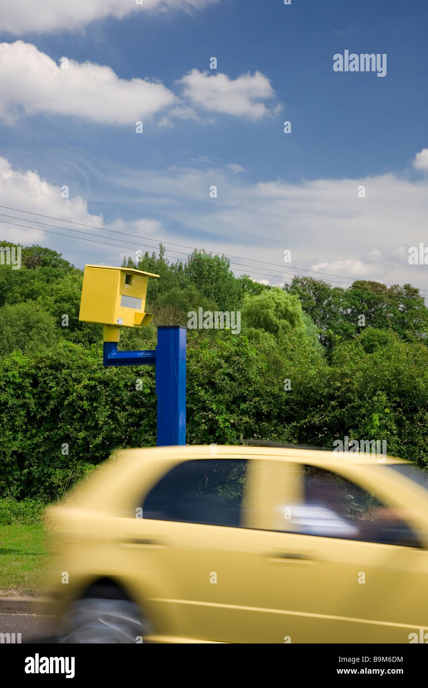 Yellow car passing by a speed camera on a UK road Stock Photo - Alamy