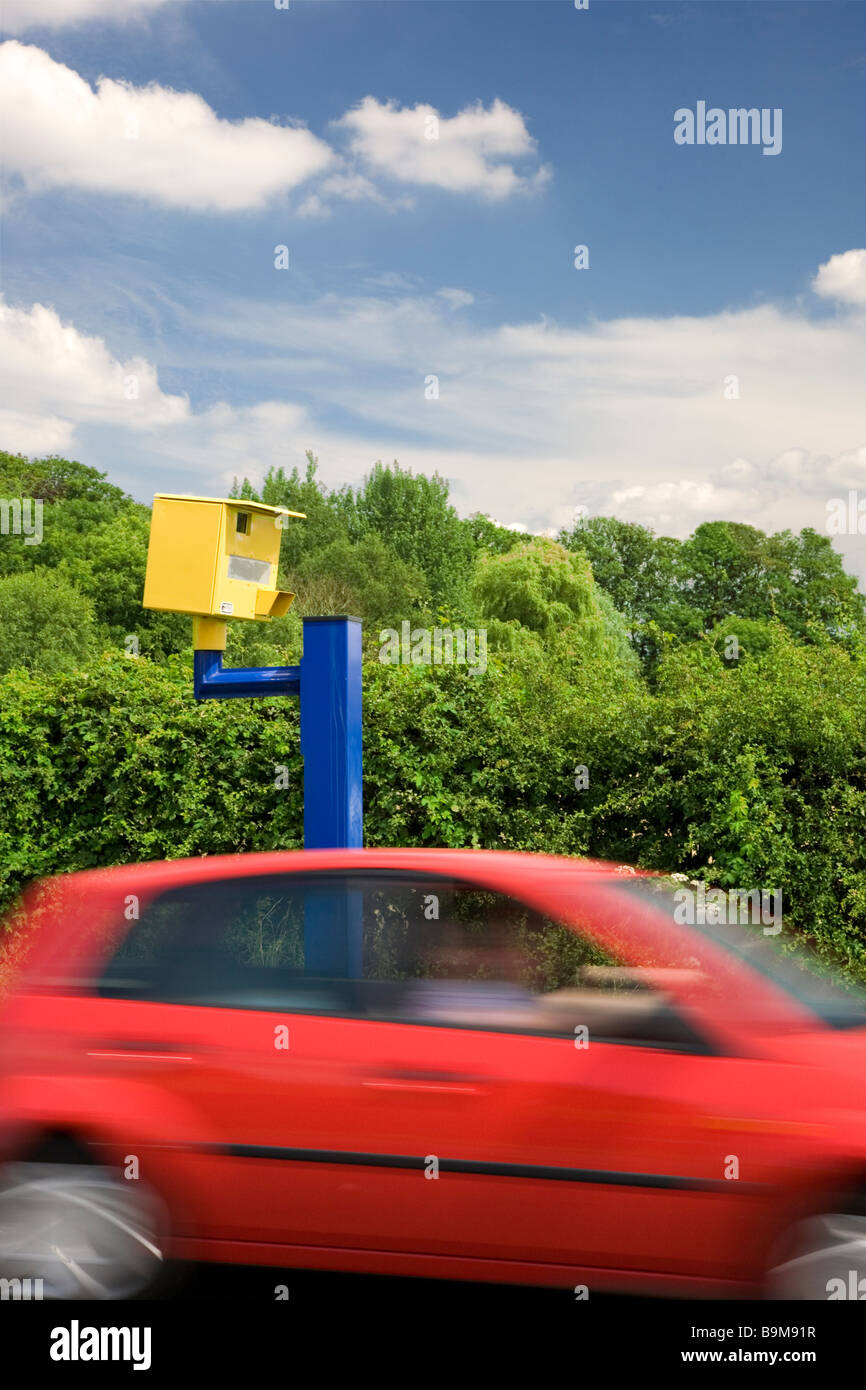 Red car passing by a speed camera on a UK road Stock Photo - Alamy