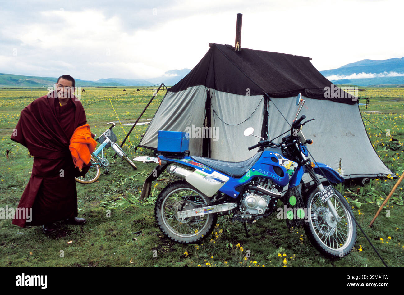 China, Sichuan province, near Litang, a young monk and his motorcycle ...