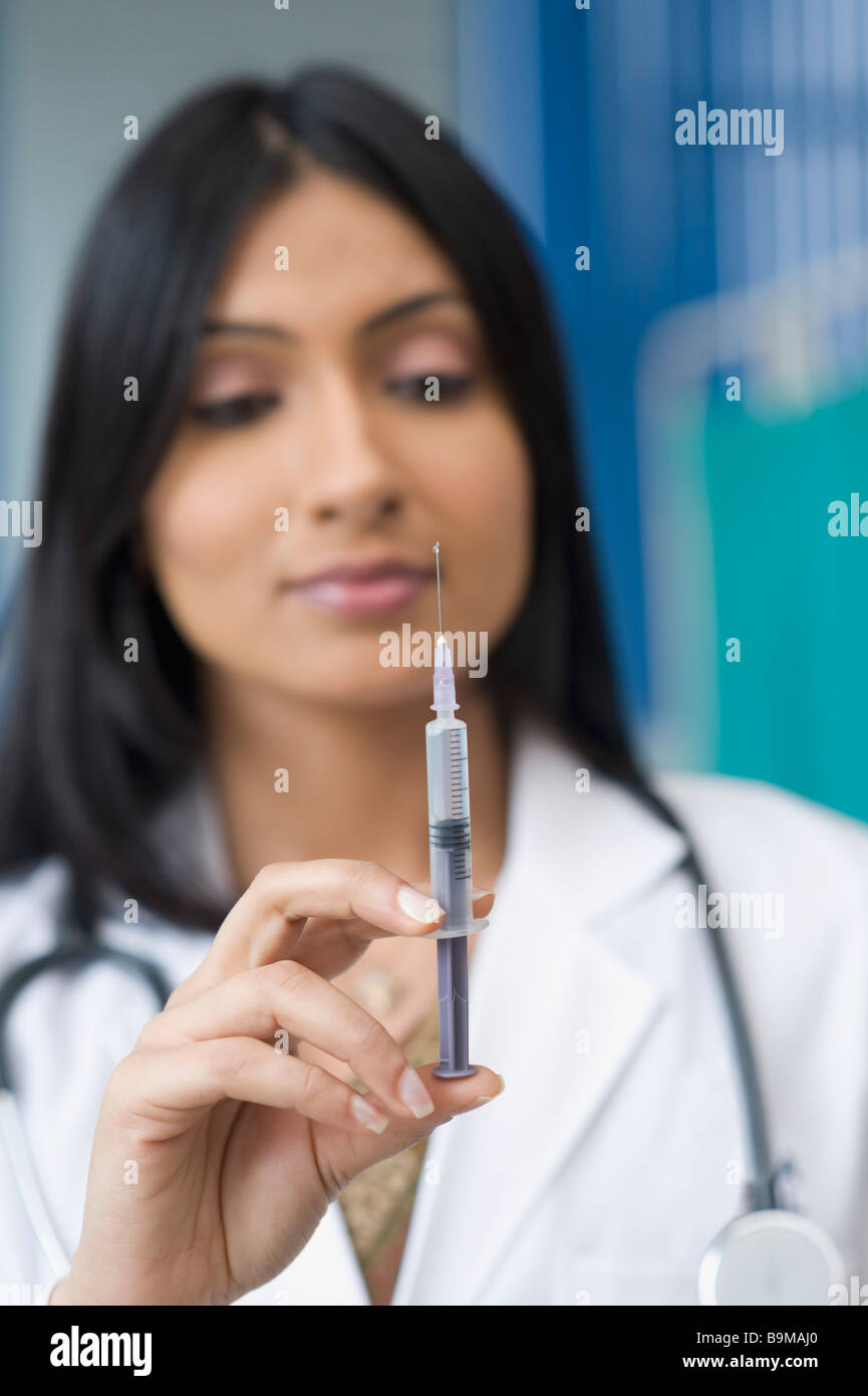 Female doctor holding an injection Stock Photo - Alamy